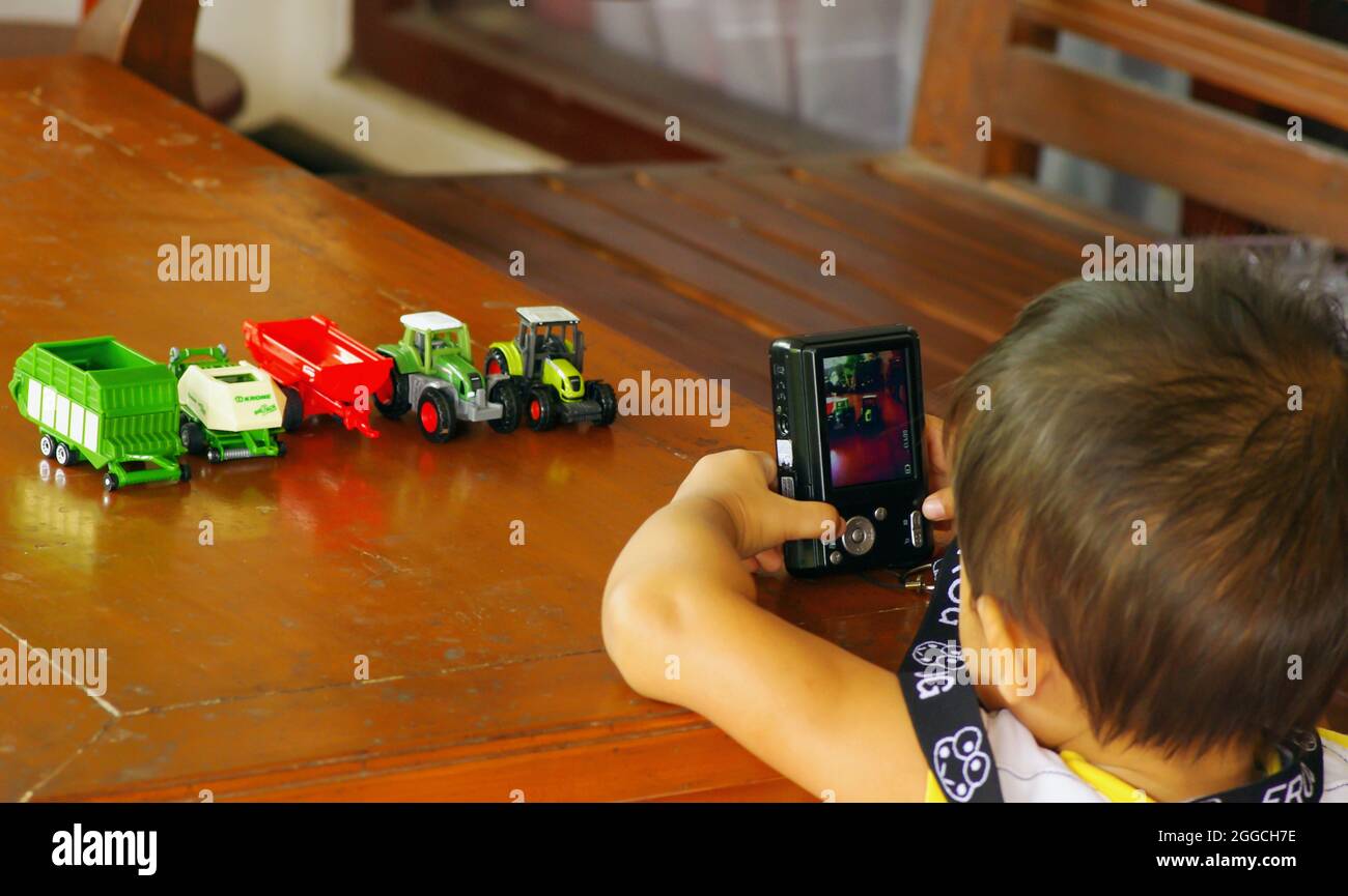 A child taking picture of his toys with pocket camera, shallow focus ...
