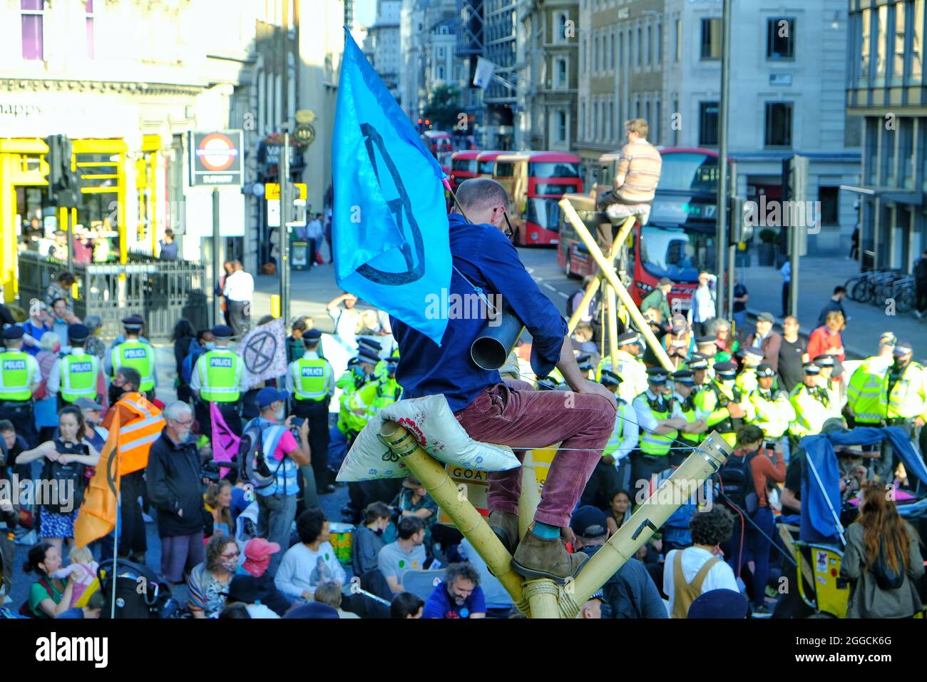 London, UK. Extinction Rebellion protesters sit atop bamboo structures ...