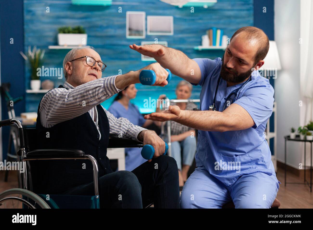Practitioner man doctor helping retiree senior male in wheelchair to do ...