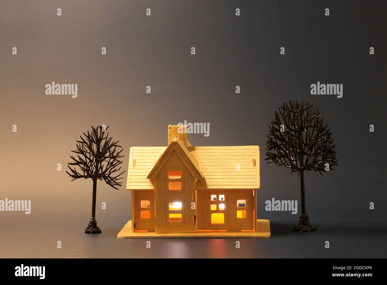 Bright wooden house with autumn trees against night black background ...