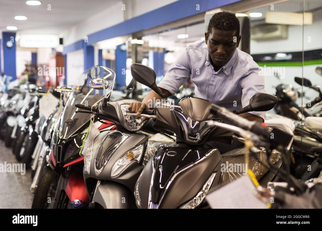 Portrait of adult man buying new motorcycle at modern showroom Stock ...