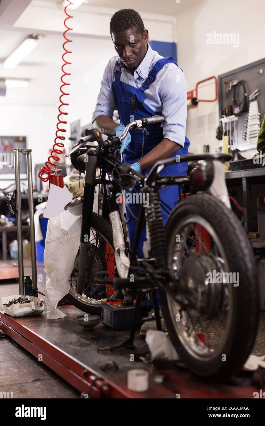 Service engineer repairs a motorcycle steering wheel in a motorcycle ...