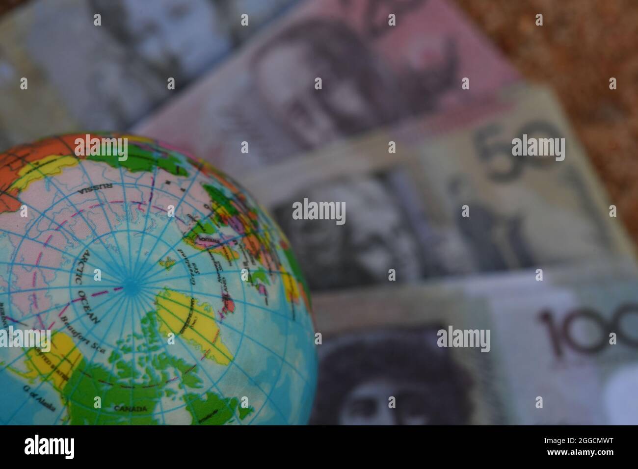Earth globe map of the Arctic, sitting on group of banknotes in nature ...