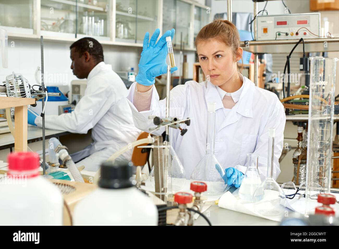 Young female lab technicians working with reagents and test tubes Stock ...