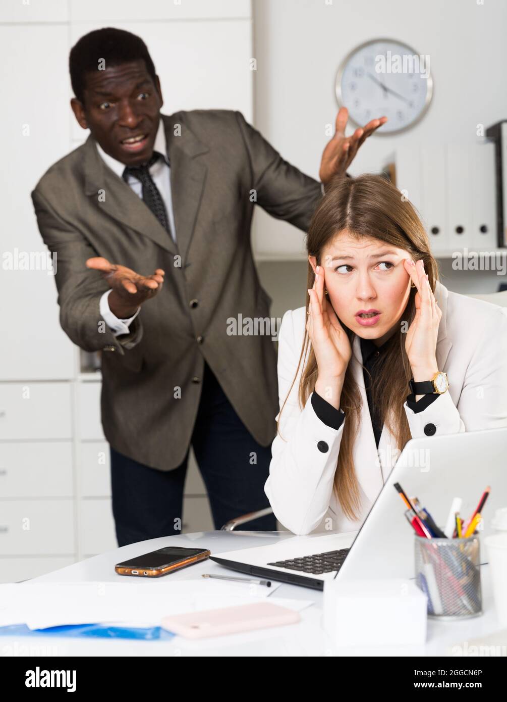 Angry man boss pointinting to misses in work to woman manager working ...