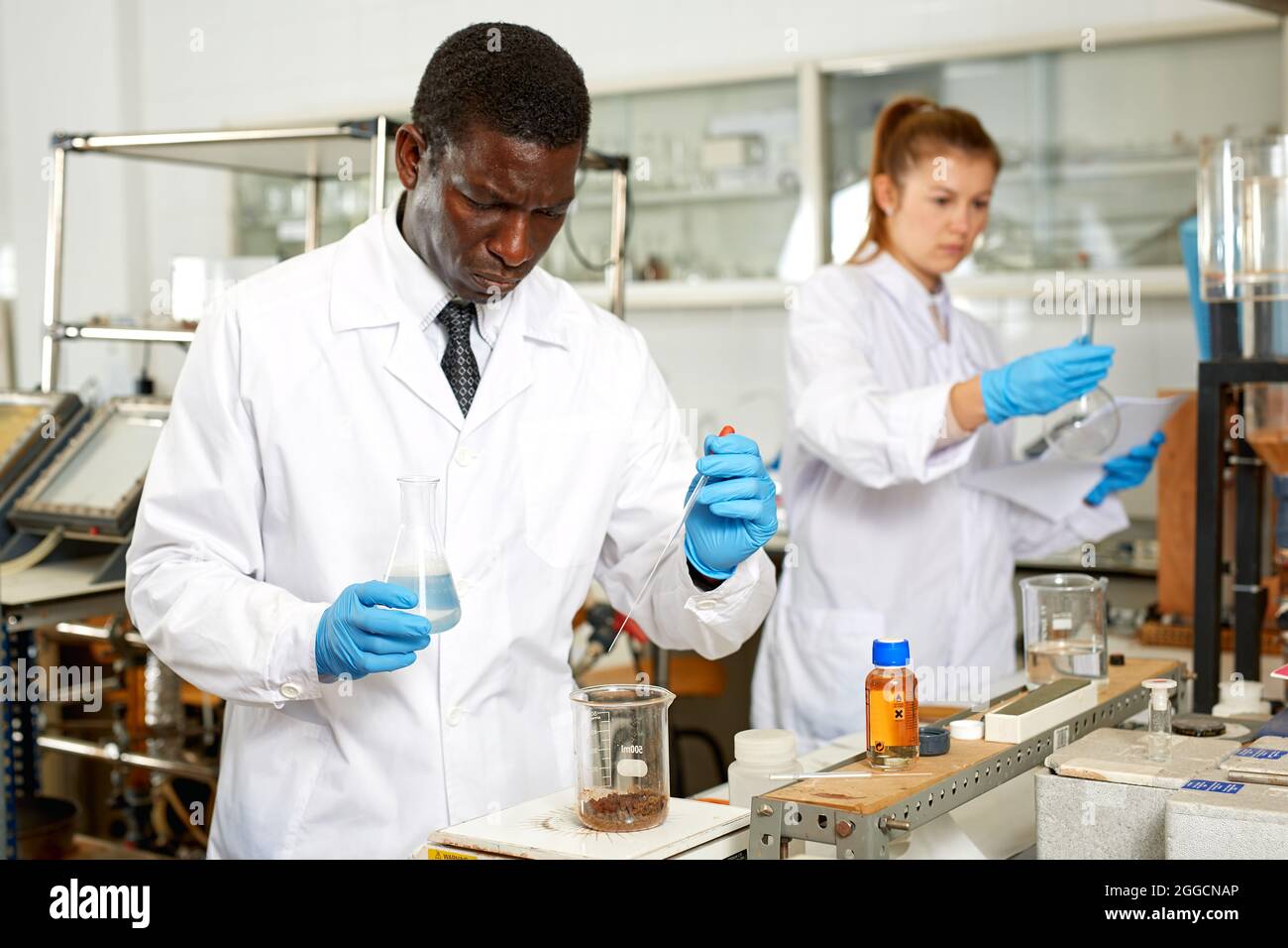Focused man lab technician in gloves working with reagents and test ...