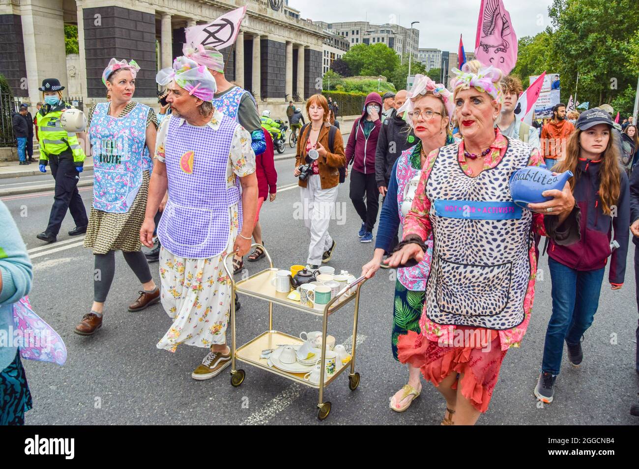Protesters in costumes push a tea trolley during the demonstration in ...