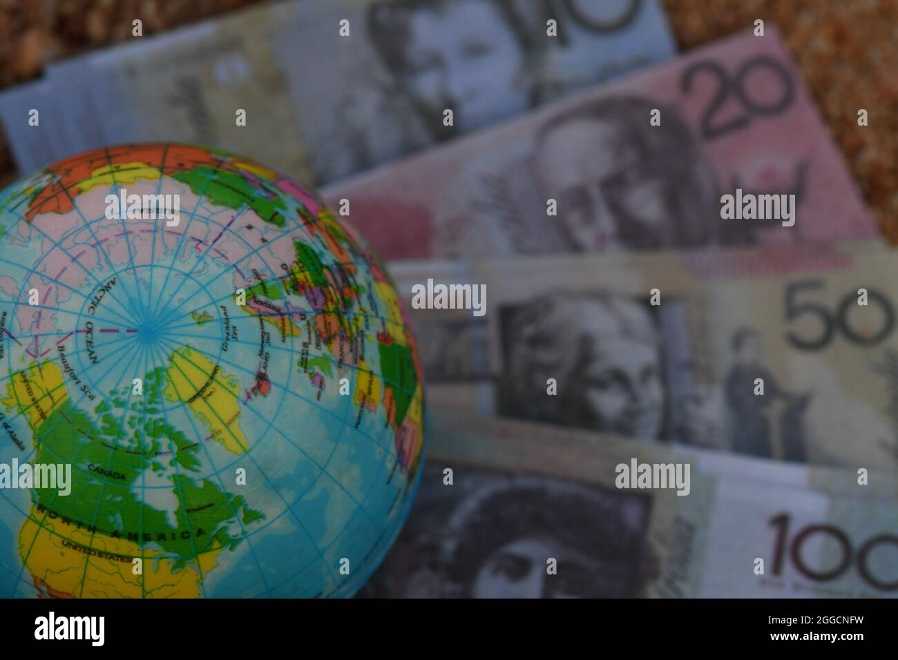 Earth globe map of the Arctic, sitting on group of banknotes in nature ...