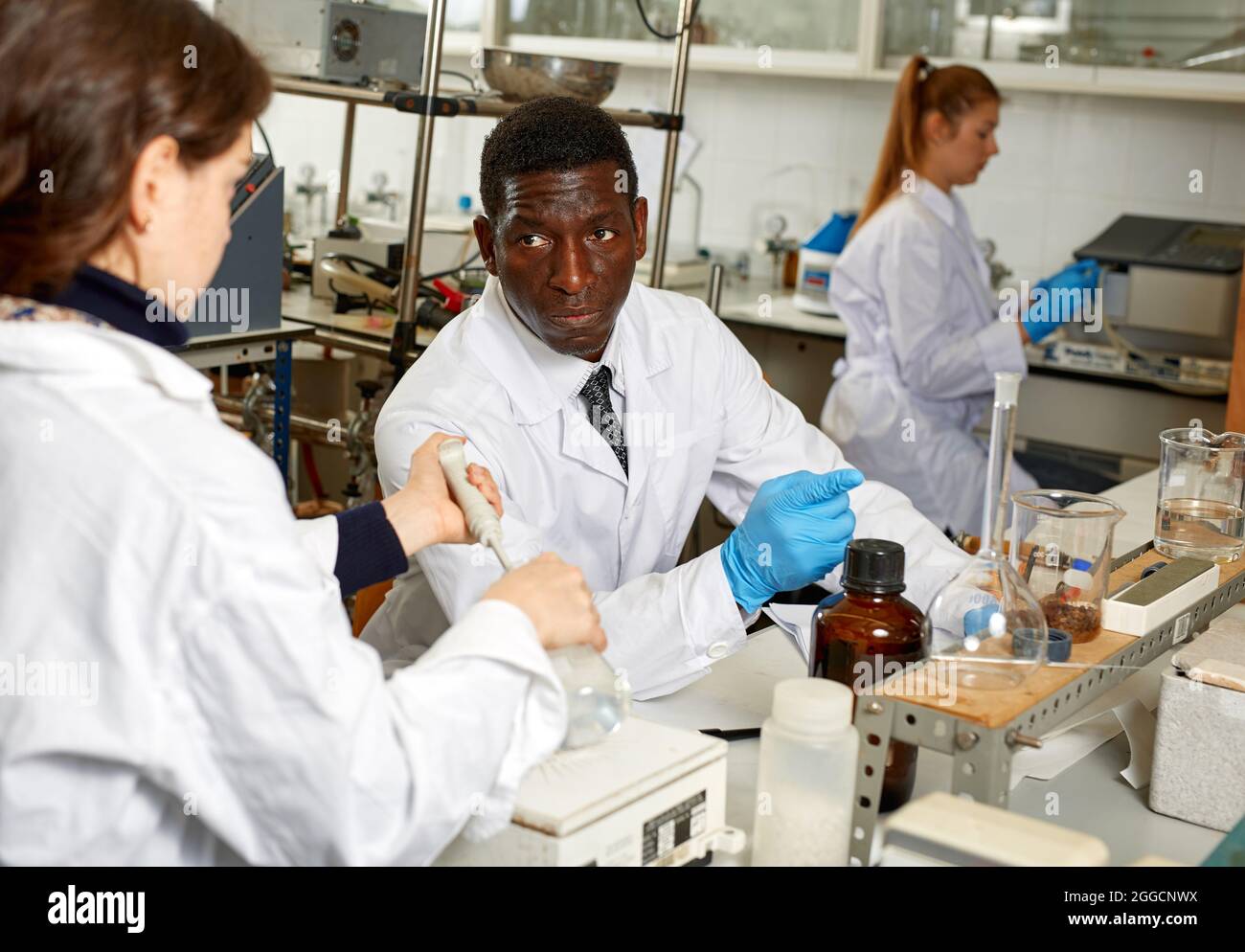 African american male lab technician writing report after chemical ...