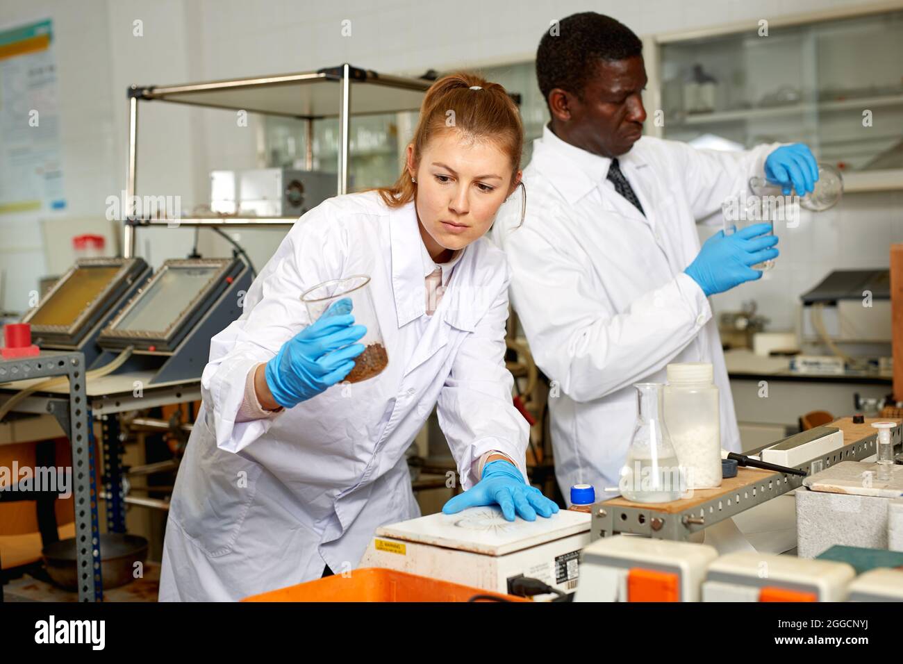 Experienced male and female scientists with glass test tubes Stock ...