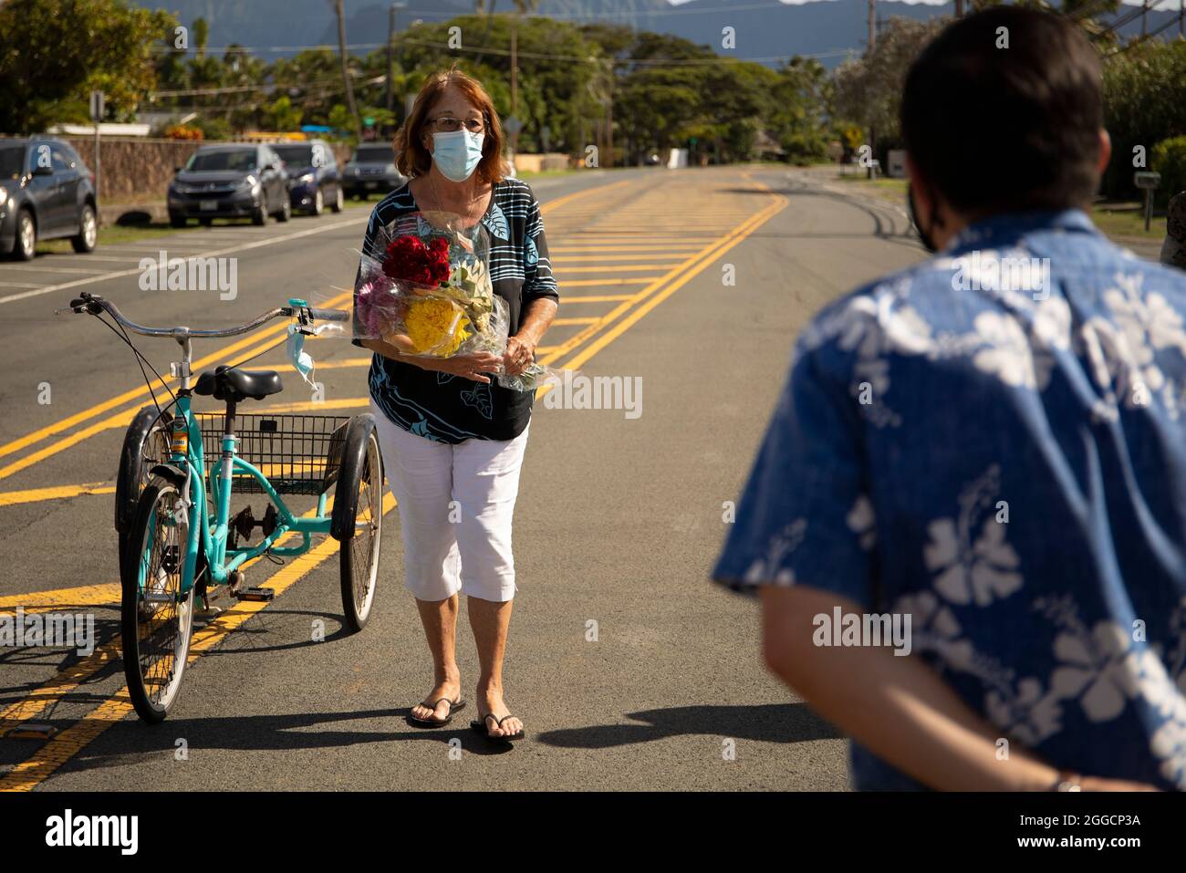 A local community member, delivers a bouquet of flowers during a ...