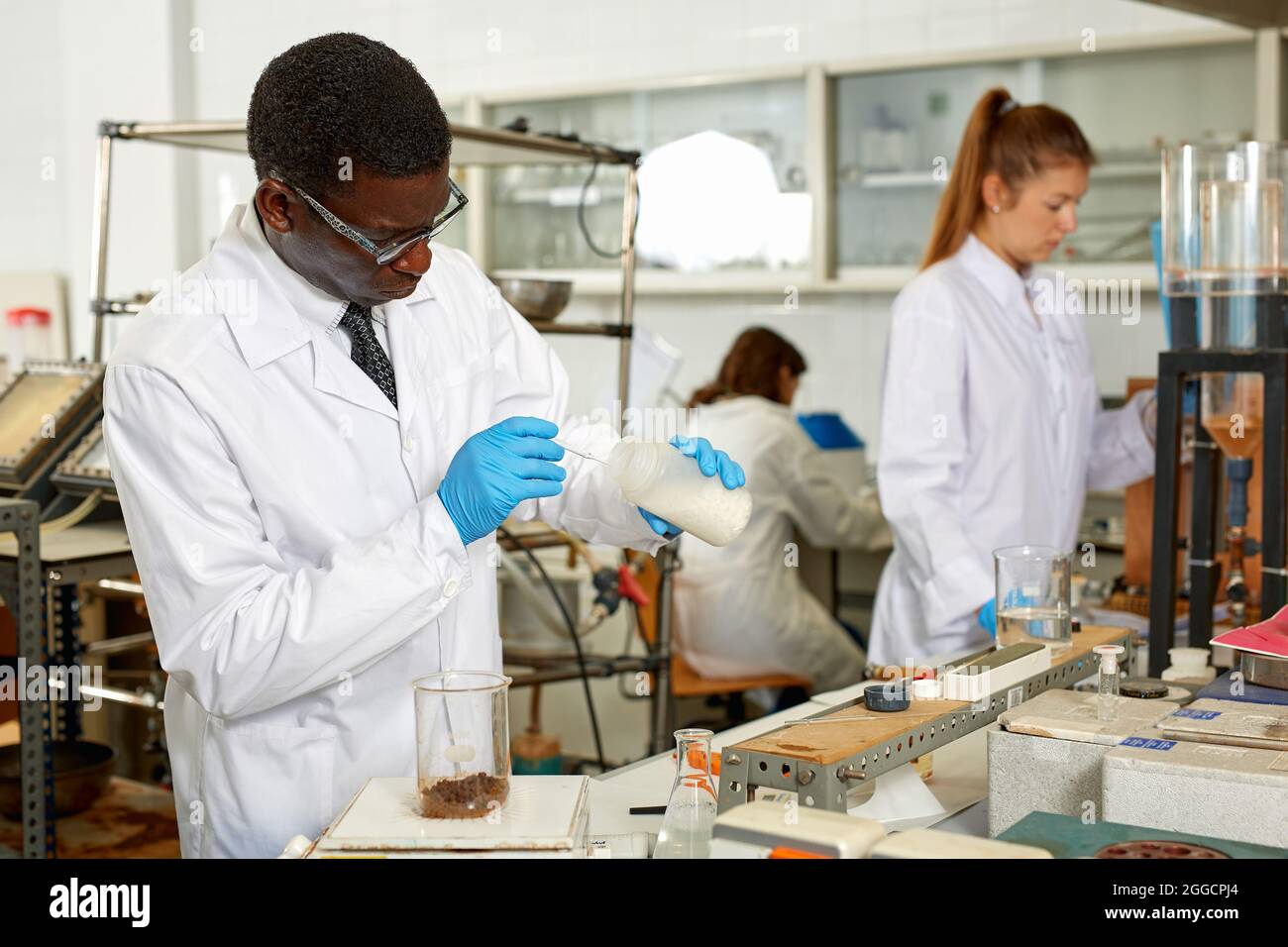Focused male lab scientist in glasses working with different reagents ...