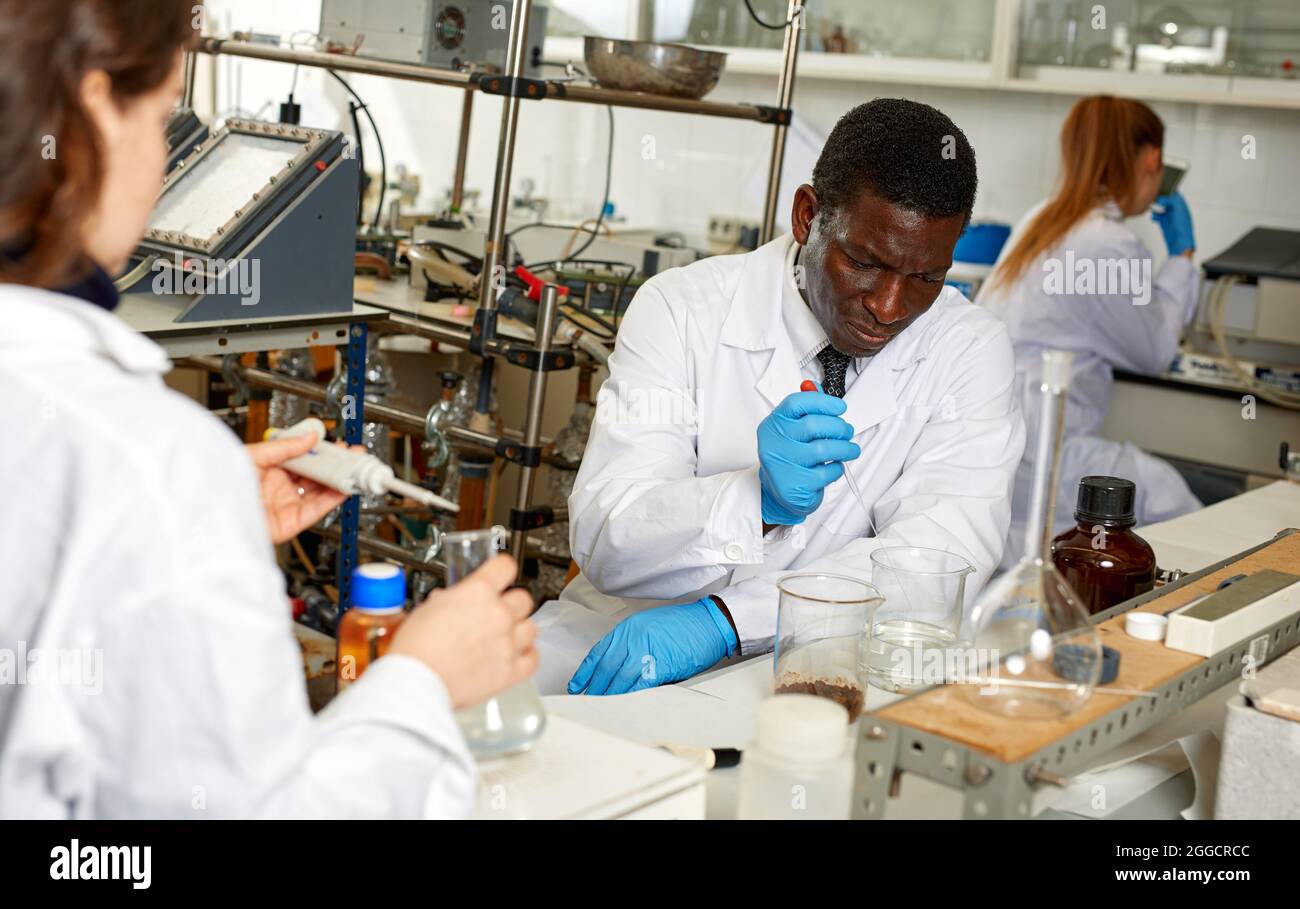 Proffesional male and female lab technicians with different test tubes ...