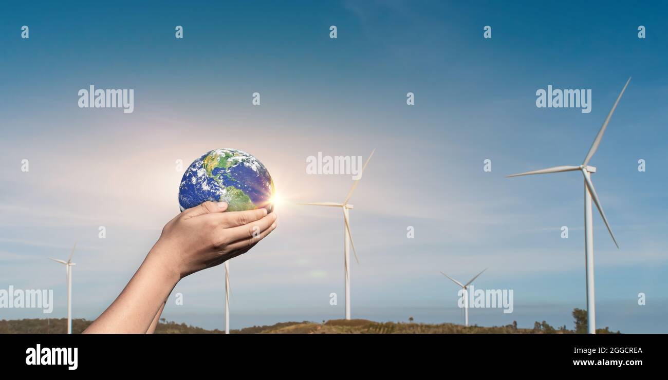 Hands holding Globe, Earth on wind turbine field background. Concept of ...