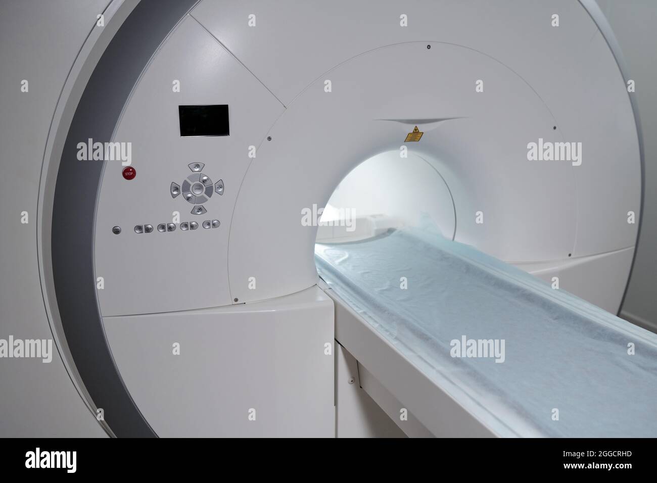 New MRI scan equipment with long table covered with napkin and panel ...