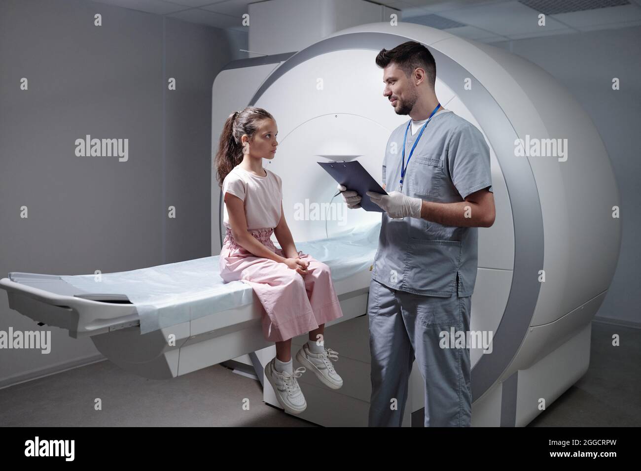 Contemporary radiologist consulting little patient before mri scan ...
