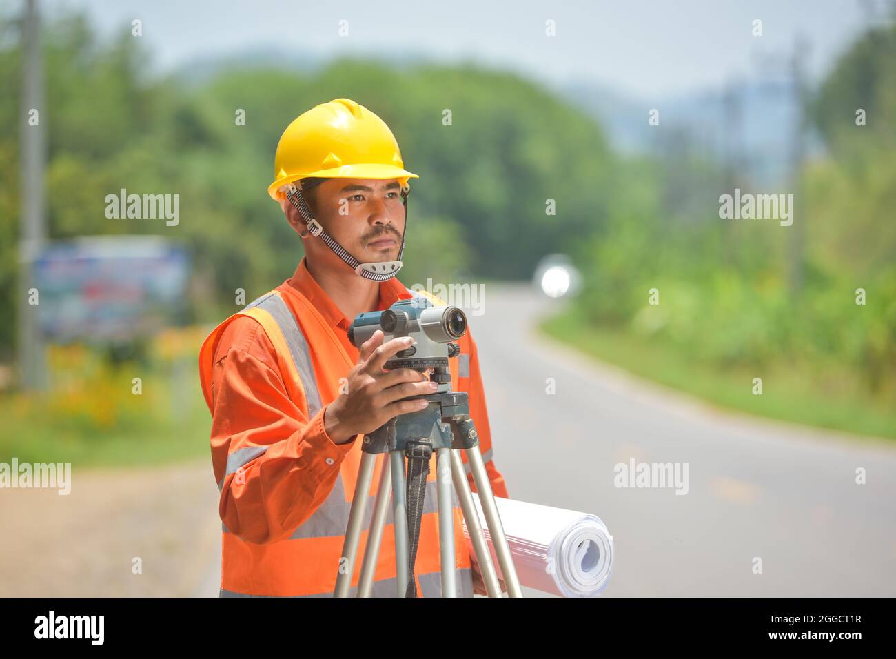 Surveyor engineer worker making measuring with theodolite on road works ...
