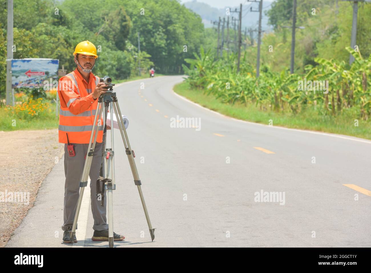 Surveyor engineer worker making measuring with theodolite on road works ...