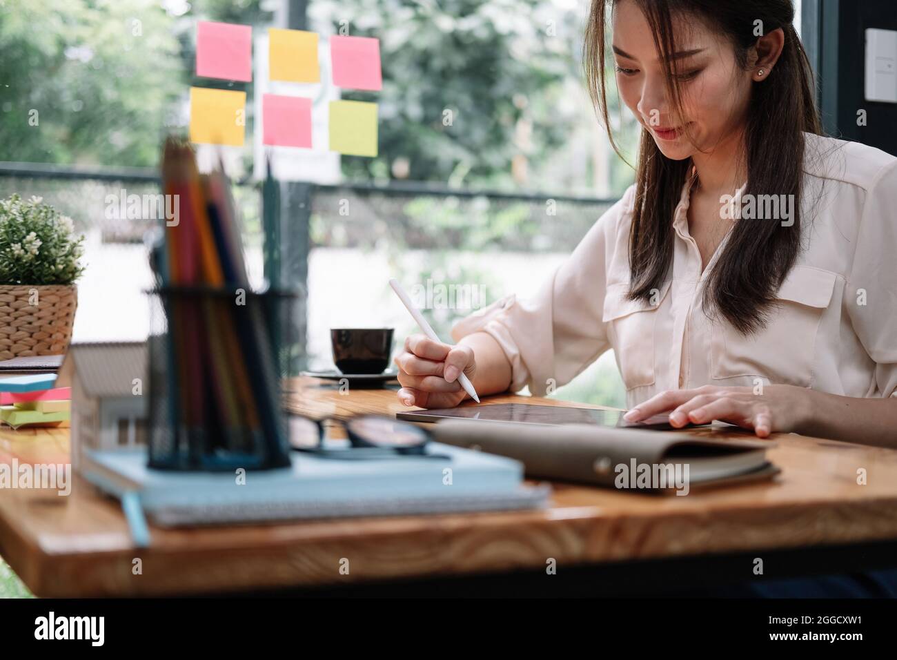Close up asian woman using computer tablet with stylus at her office ...