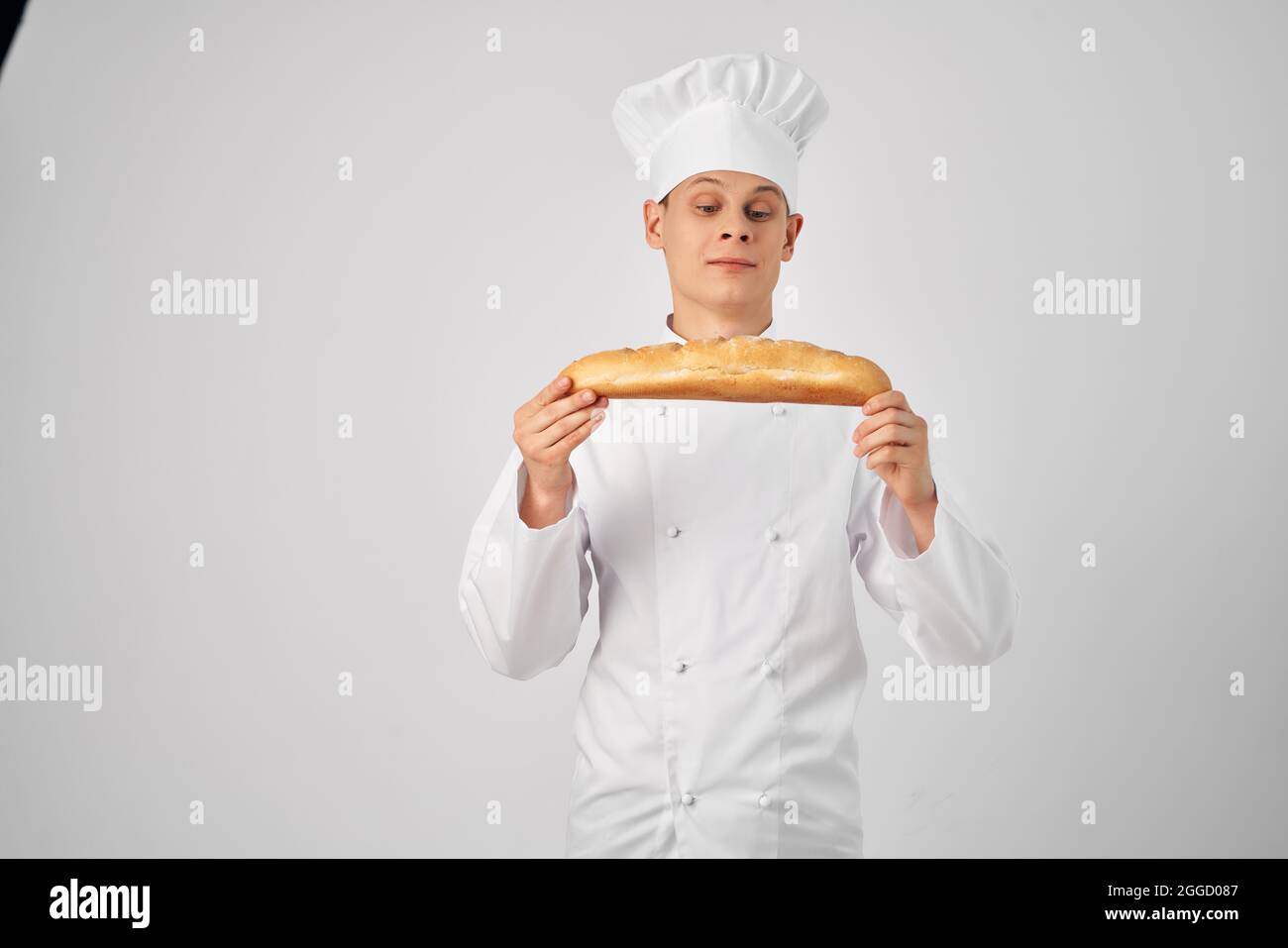 a man in chef's clothes Holding a loaf baker Professional Stock Photo ...