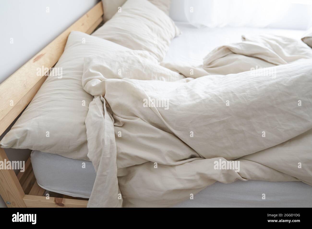 A bed in the interior of the room. Top view. The bed is not made. Beige ...