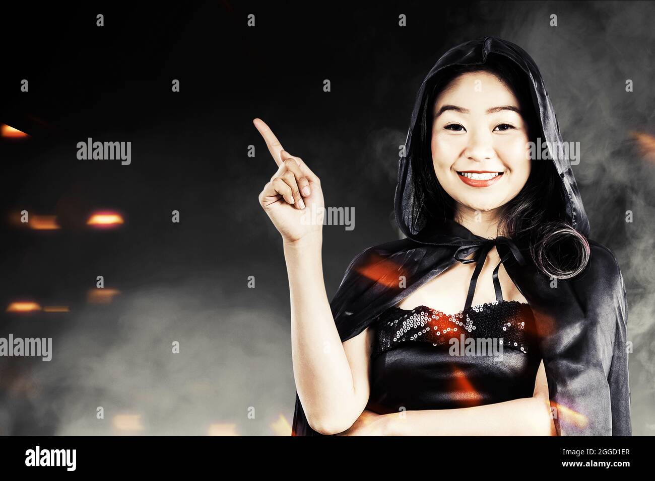 Asian witch woman with a hat standing with pointing something a black ...