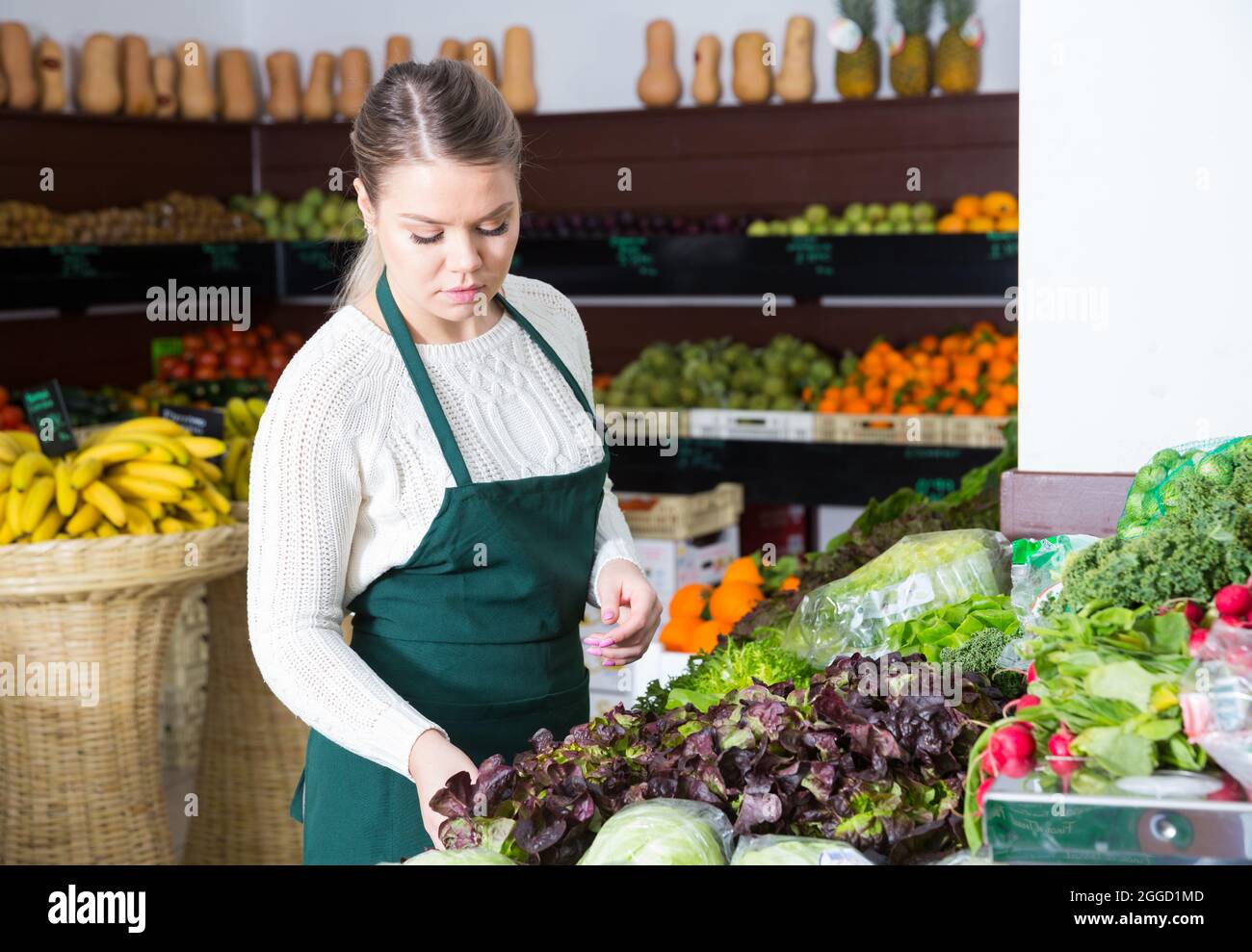 Female seller working with greens and letuce on the supermarket Stock ...