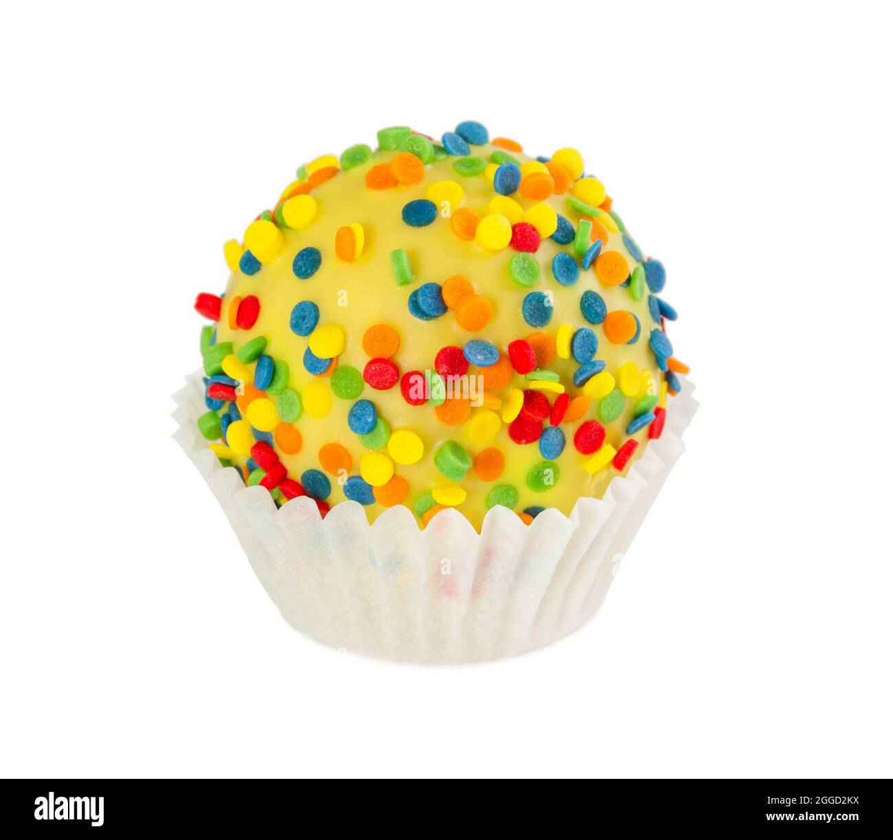 Cake ball in yellow glaze with colorful sprinkles in paper form ...