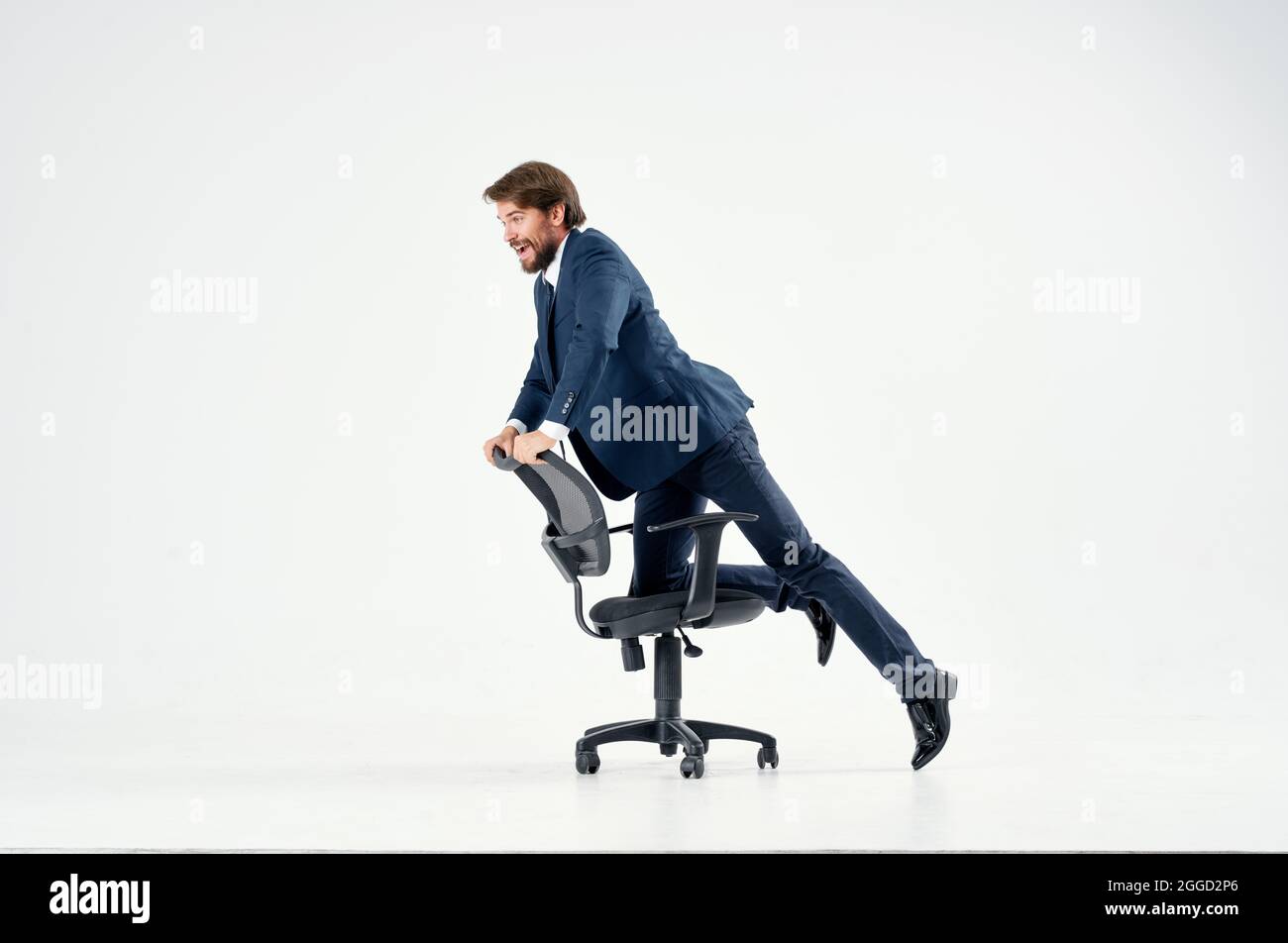 business man in a suit riding on an office chair emotions Stock Photo ...
