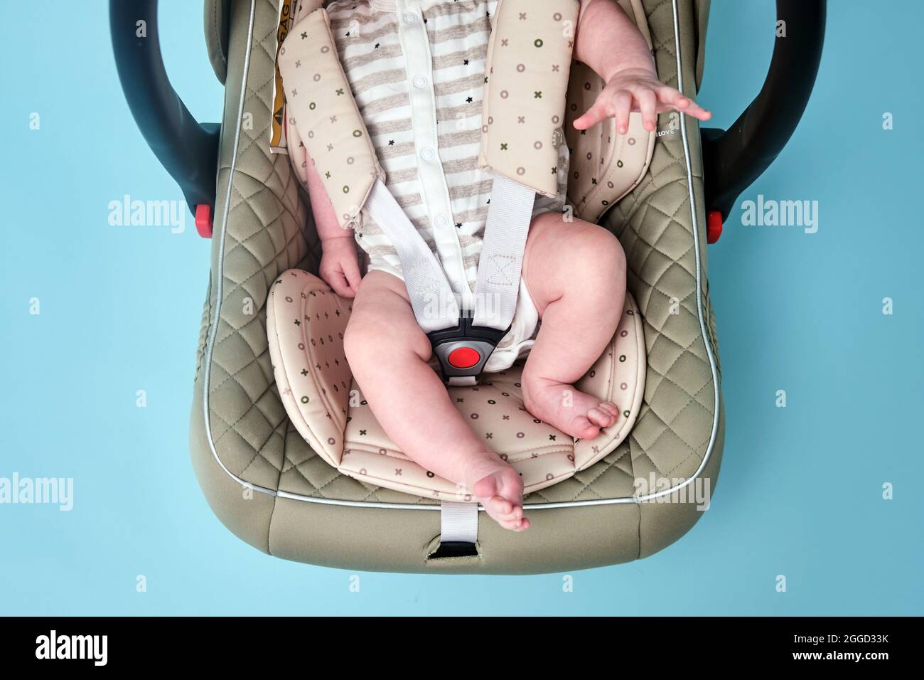 Baby in infant car seat on blue studio background. Carrier for ...