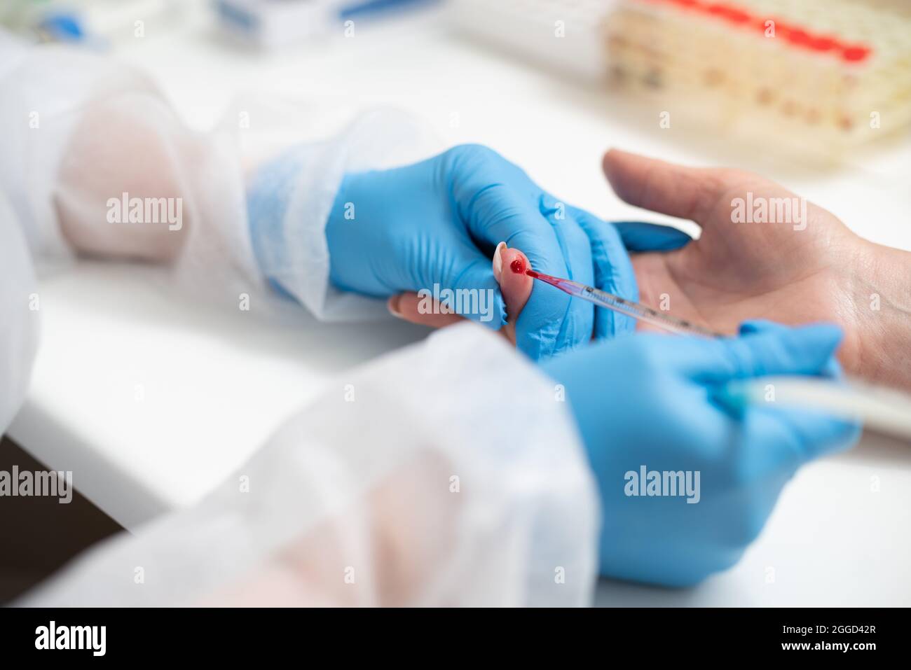 The nurse pokes a finger to collect a drop of the patient's blood ...