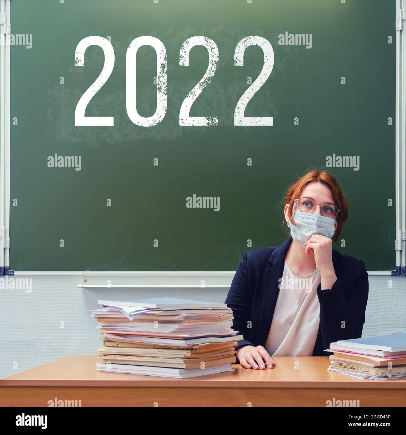 Woman teacher in school class with chalk inscription 2022 on blackboard ...