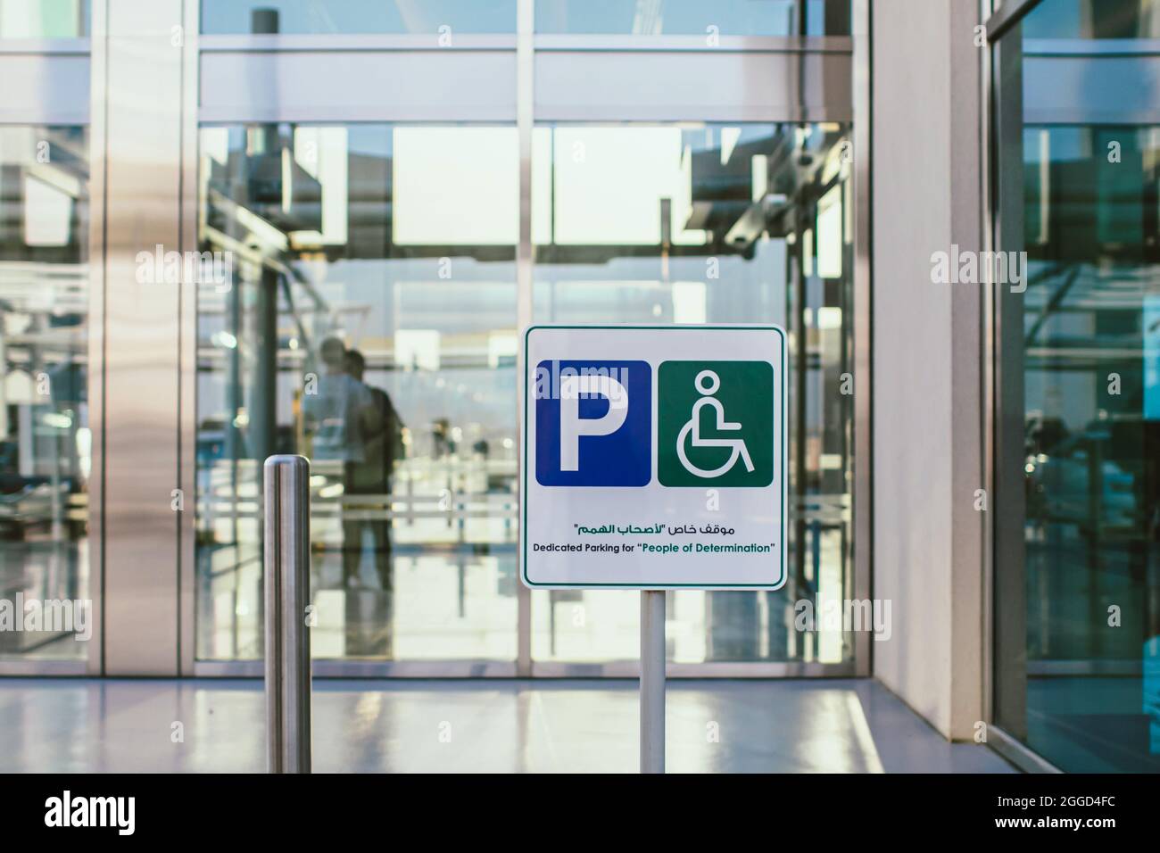 White parking sign on the street showing direction for people and cars ...