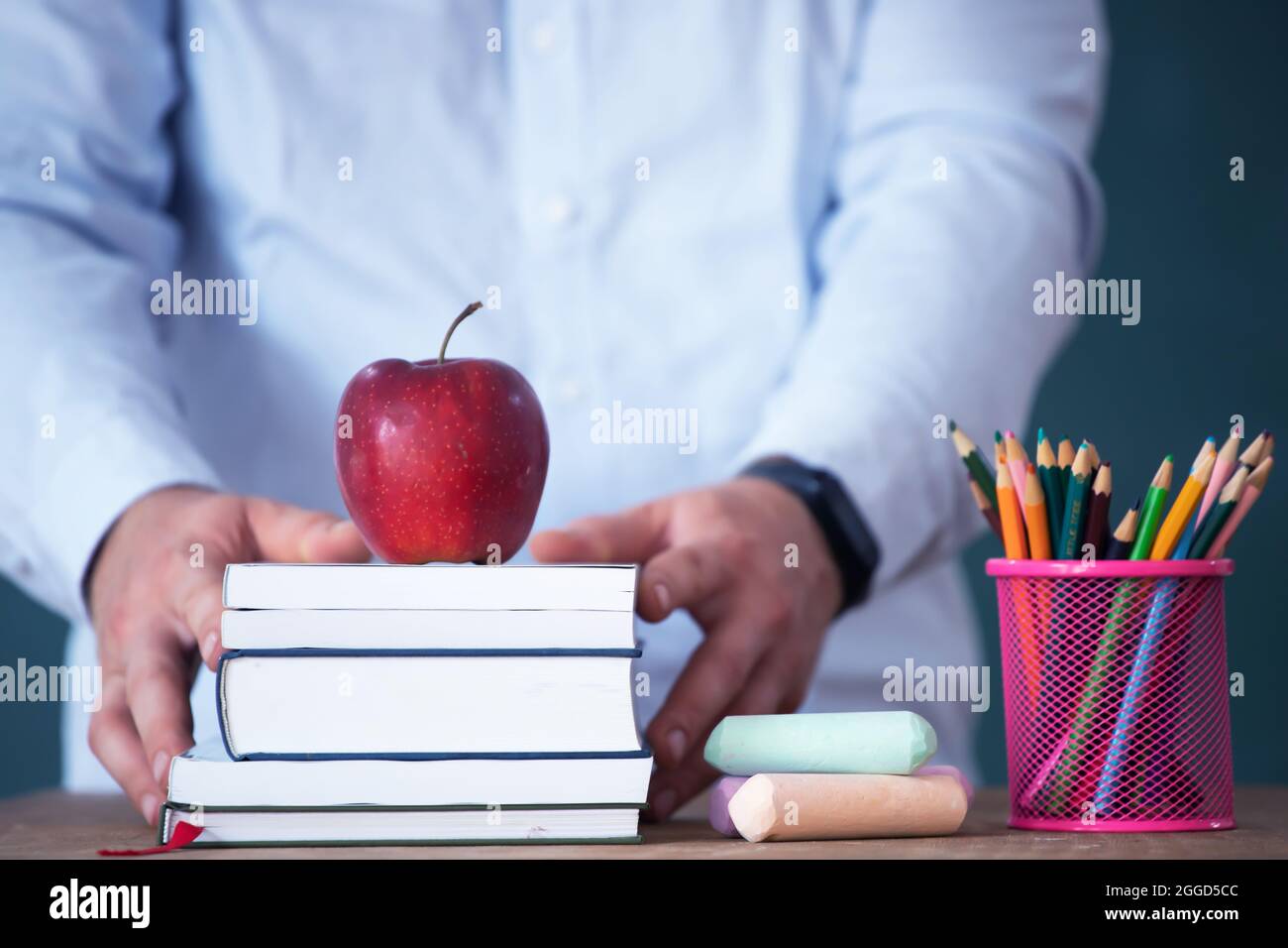 Back to school concept: teacher giving books to her studens in the ...