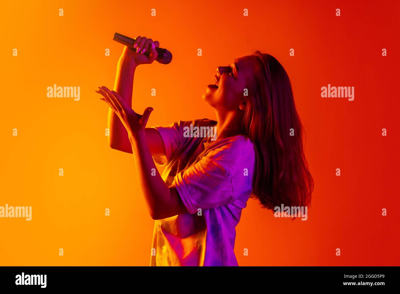 Side-viewed cropped portrait of young beautiful caucasian girl singing ...