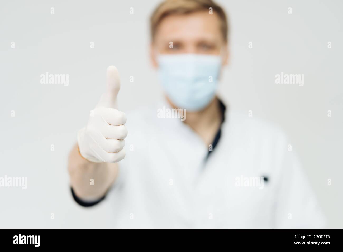 Attractive male doctor show thumbs up hand sign isolated on white ...