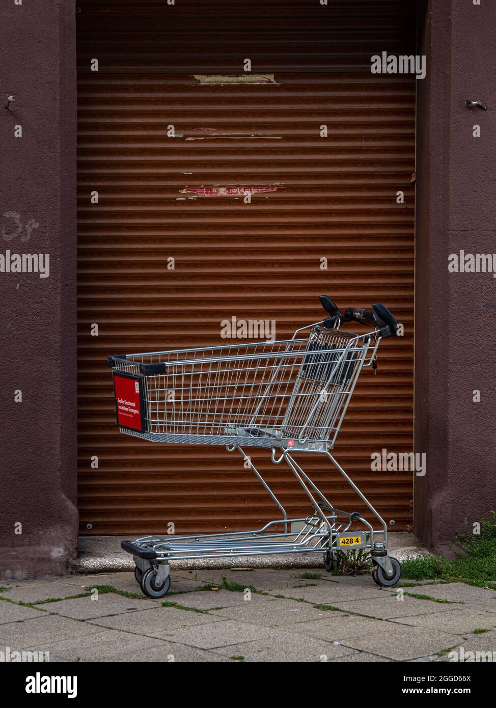 Mall pushcart left in front of a closed roll-up door Stock Photo - Alamy