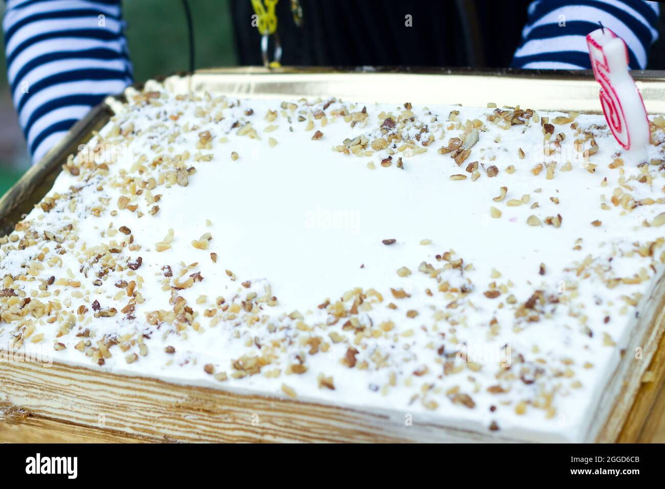 Woman holds a festive nut cake with a candle Stock Photo - Alamy