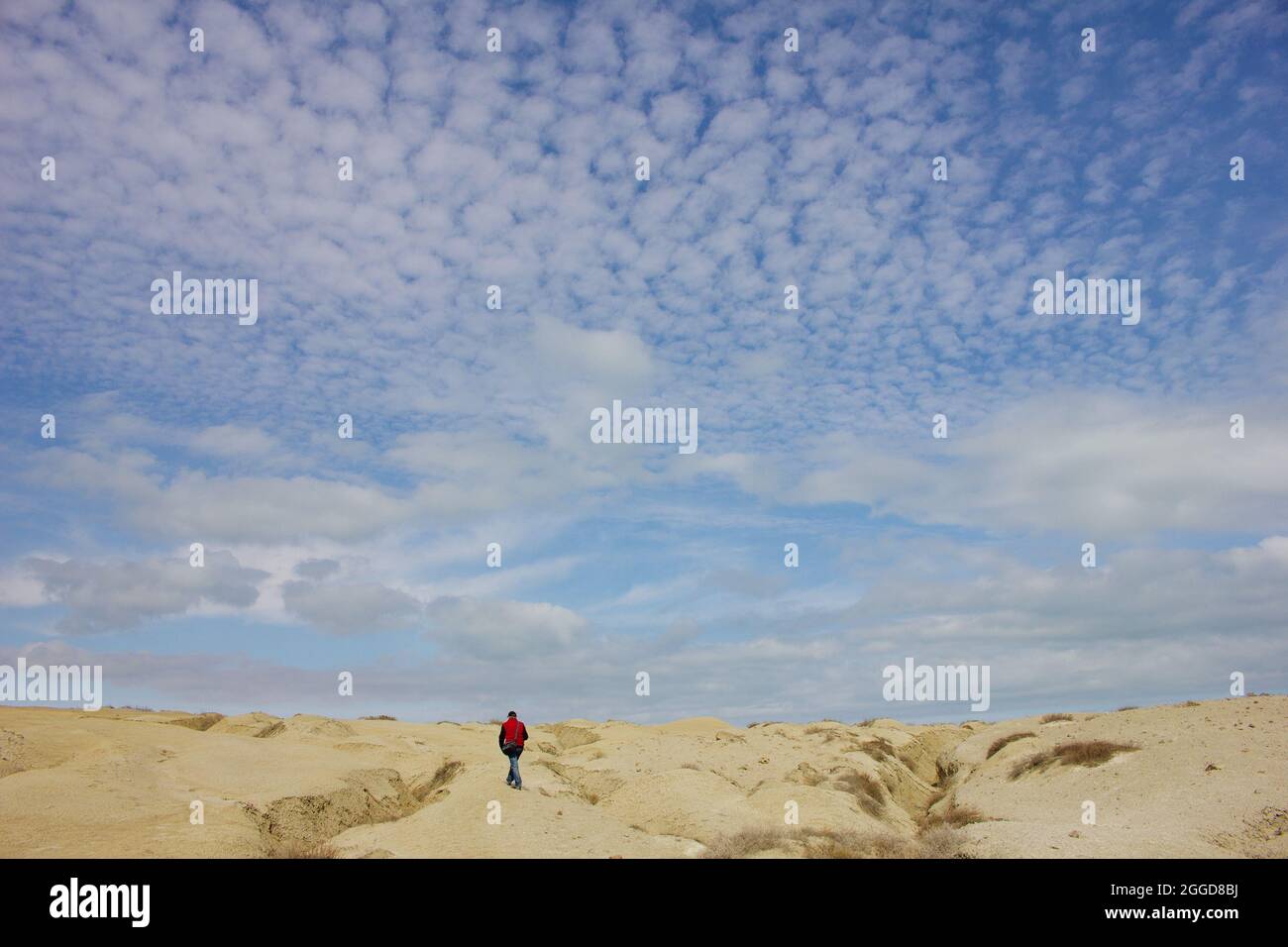 A man walking on a plain into the distance Stock Photo - Alamy