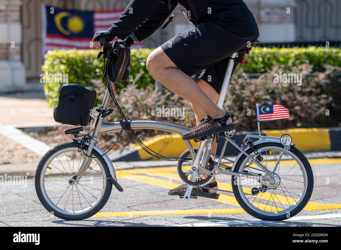 Kuala Lumpur, Malaysia. 31st Aug, 2021. A citizen rides a bike with a ...