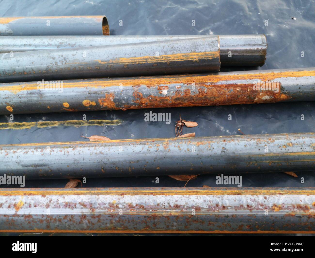 Rusty old metal tubes on the ground Stock Photo - Alamy