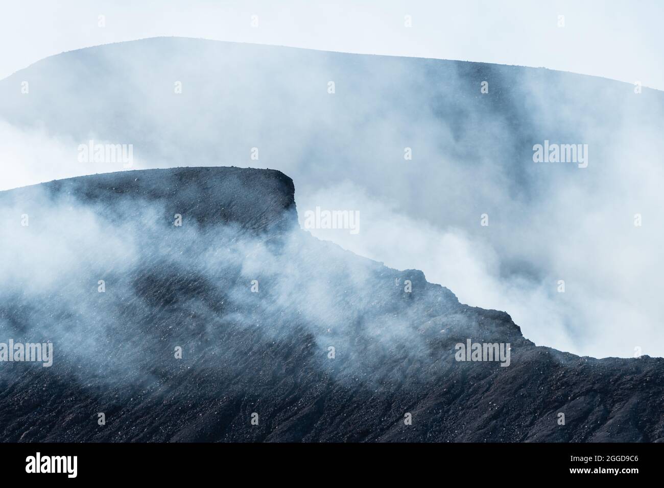 Sulfur gas coming out of the dark edge of the active volcano crater ...