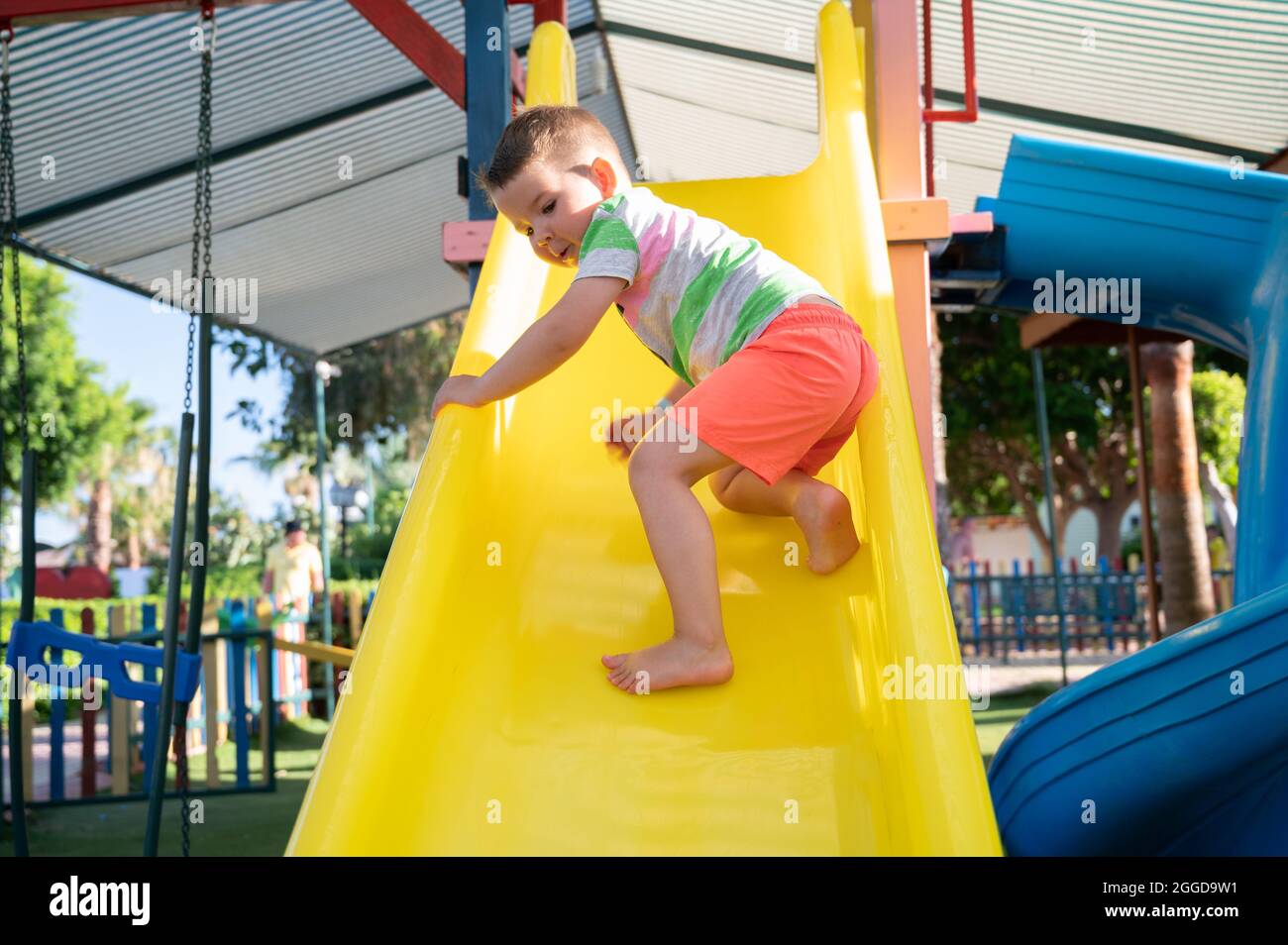 The child is afraid of rolling down the children's slide Stock Photo ...