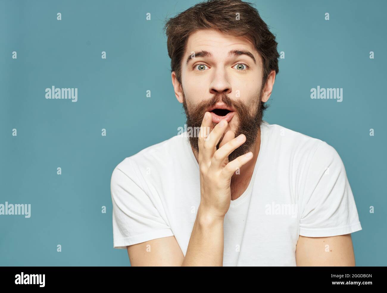 Man in a white t-shirt hand gestures anger blue background Stock Photo ...