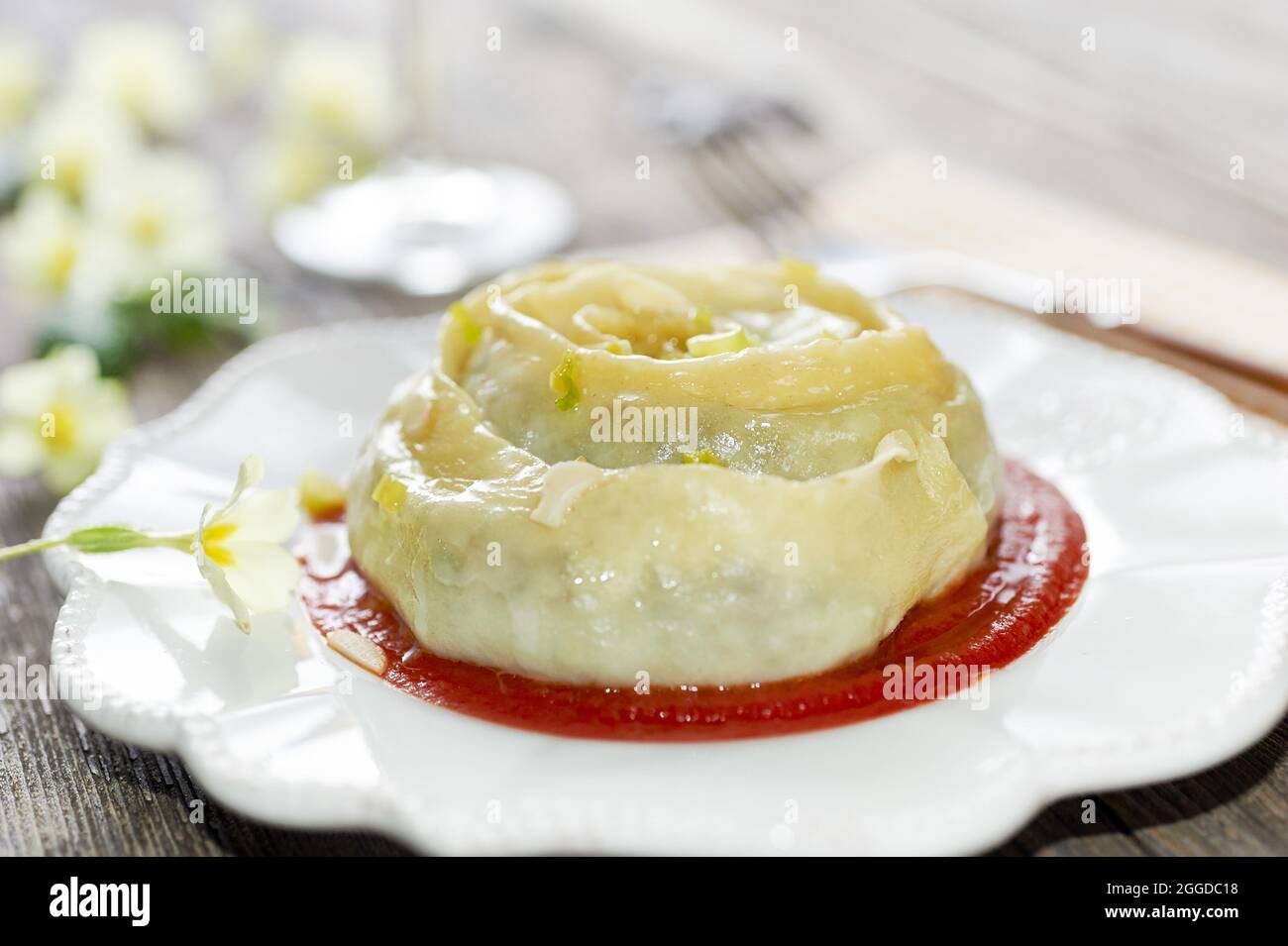 Roll pastry with nettle filling and tomato sauce Stock Photo - Alamy