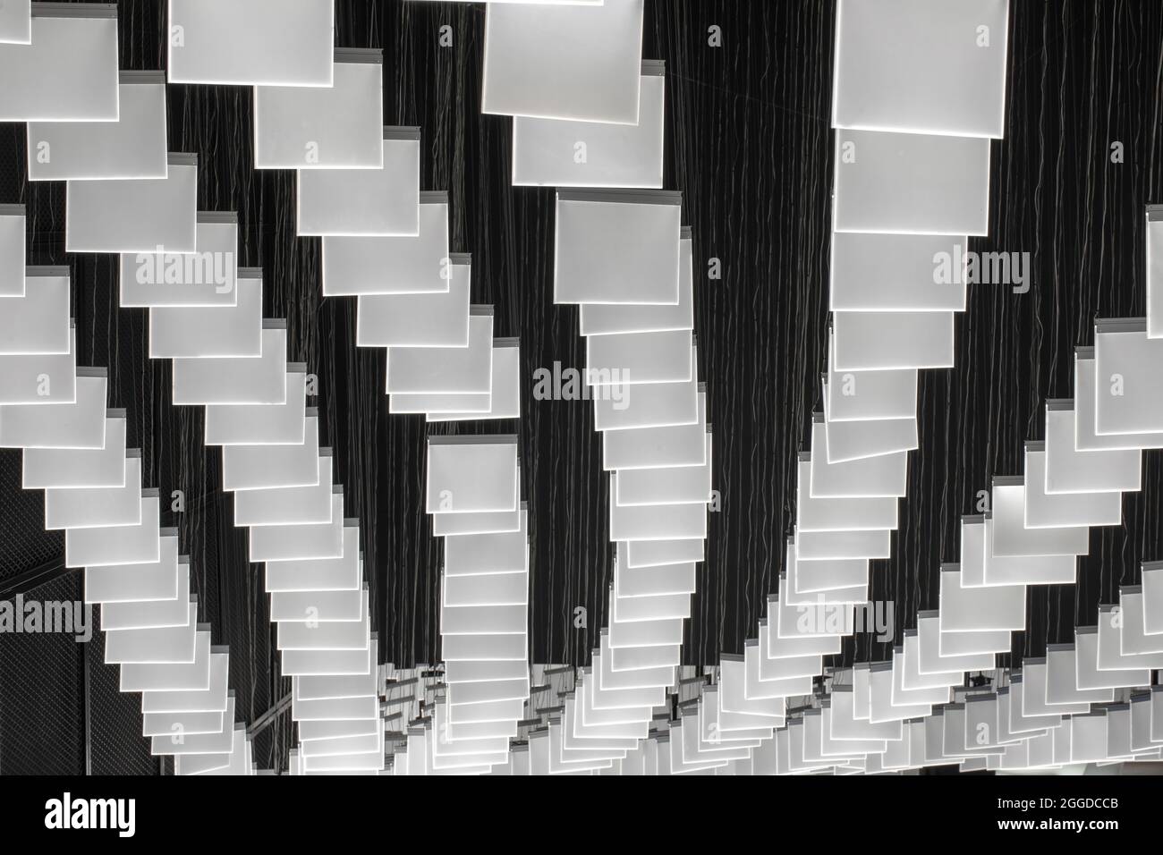 Row of contemporary hanging square LED lighting in modern building with ...