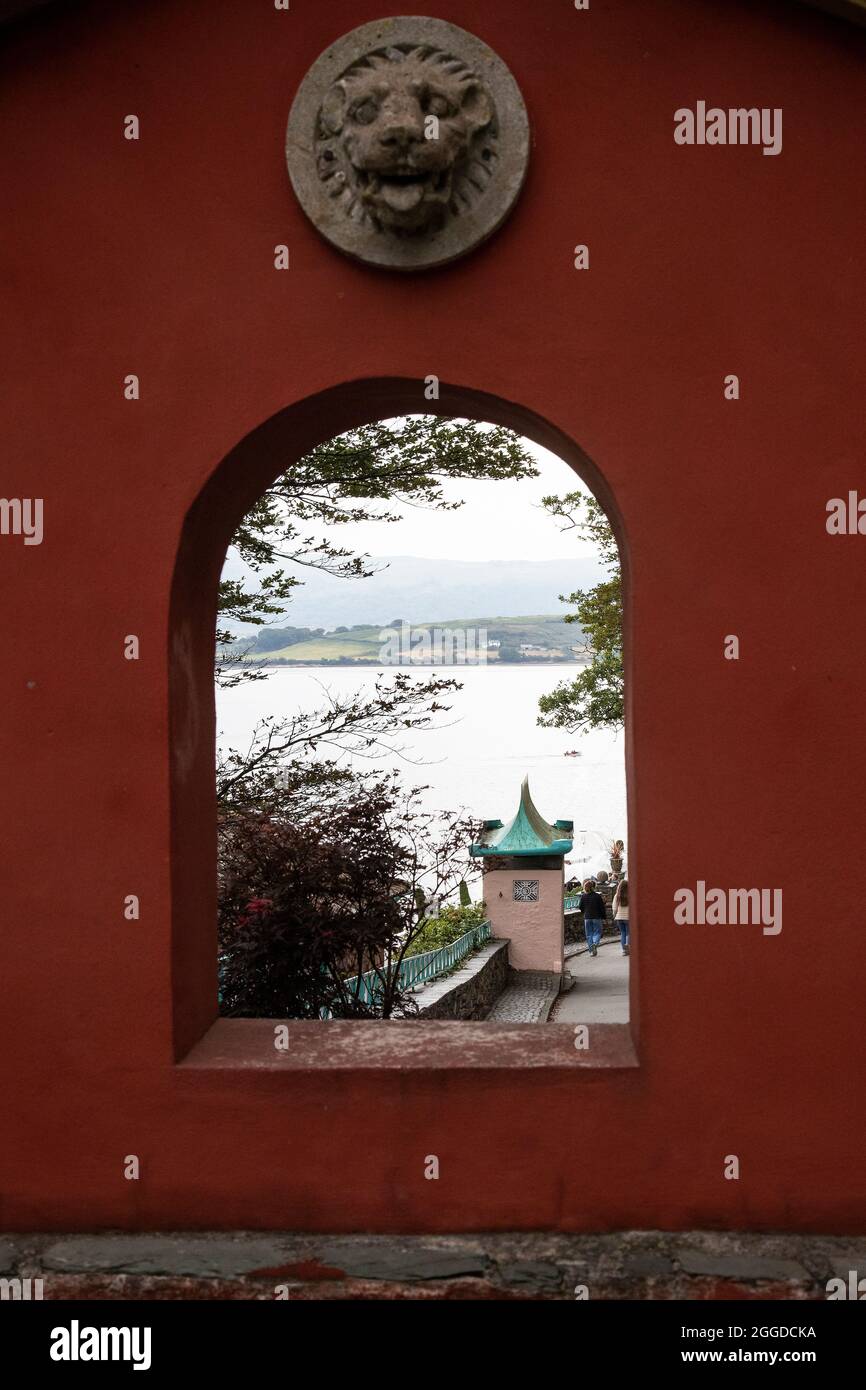 Stone wall arch with insignia and view to the gardens and Afon Dwyryd ...