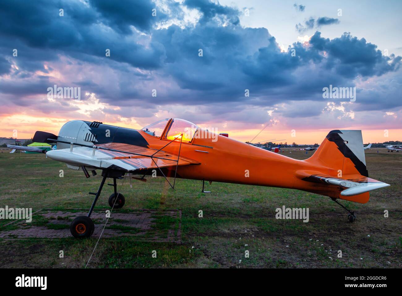 Orange sports airplane parked at the airfield at scenic sunset Stock ...