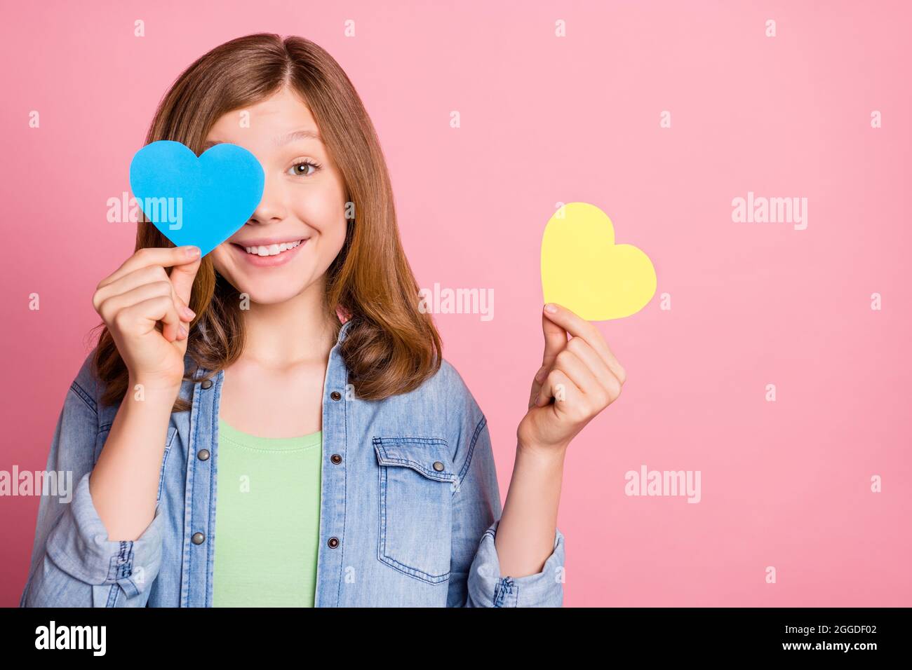 Photo portrait girl smiling hiding eye behind paper heart isolated ...