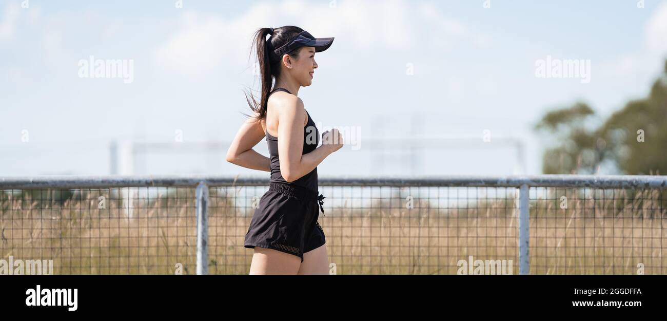 Southeast Asian female runner in black sports attire jogging in the ...